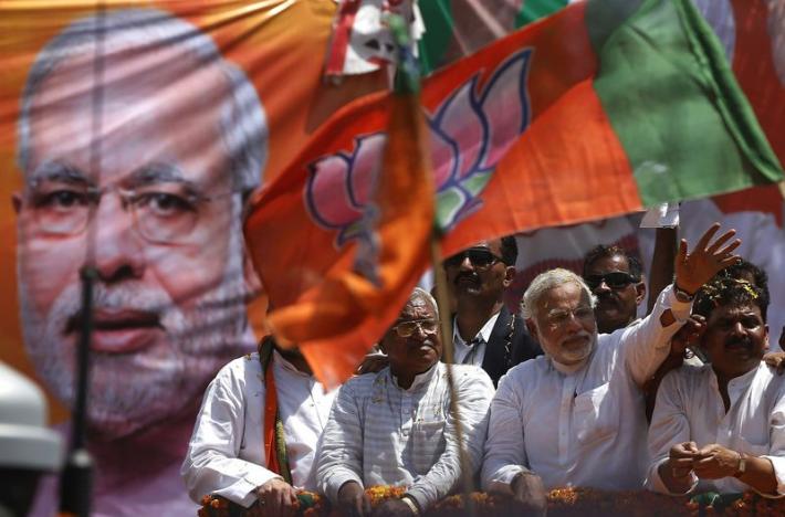 Modi waves to his supporters as he arrives to file his nomination ...